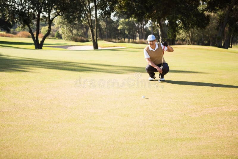 Golfer Crouching on Golf Course Stock Image - Image of black, balance ...