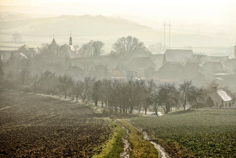 Distant Village in Fog with Rural Road between Fields Stock Photo ...