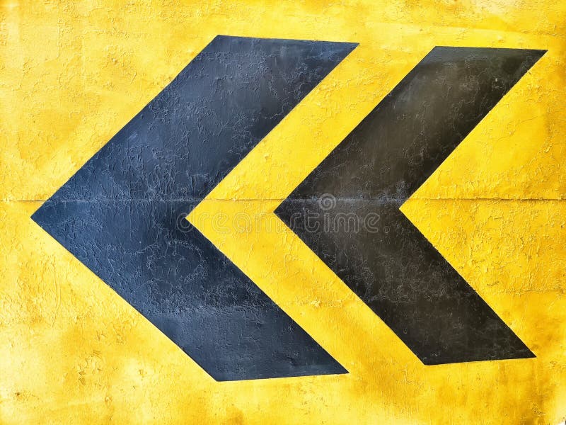 Distinctive Black and Yellow Directional Arrows on Textured Wall ...