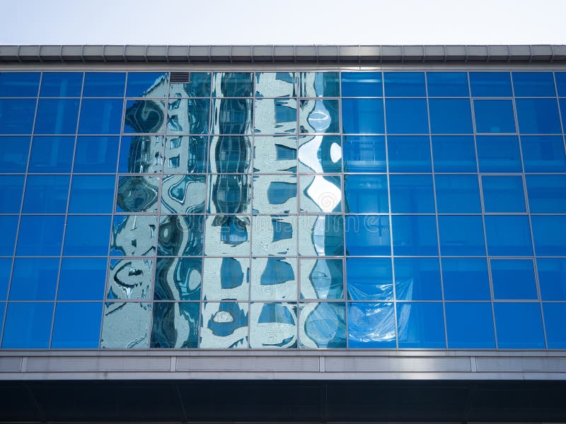 Distorted Architecture Reflected in Blue Glass Wall of Office Building ...