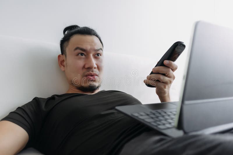 Distracted Creative Designer Man Lying on Sofa Working Watching Tv ...