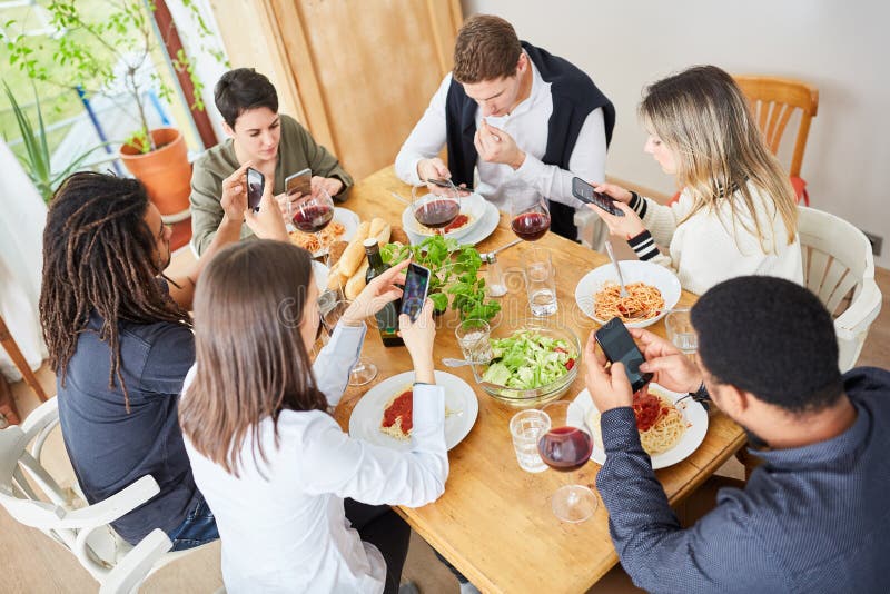 Distracted Friends Look at Smartphone while Having Lunch Together Stock ...