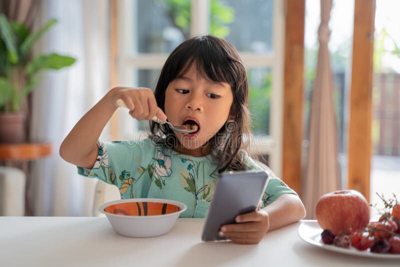 Distracted Kid Using Mobile Phone while Having Breakfast Stock Photo ...