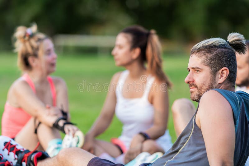 Distracted Man among a Group of Friends with Inline Sake in a Park ...