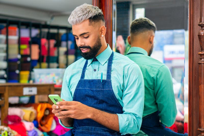 Store Seller Using Mobile Phone To Check Messages at Fabric Store Stock ...
