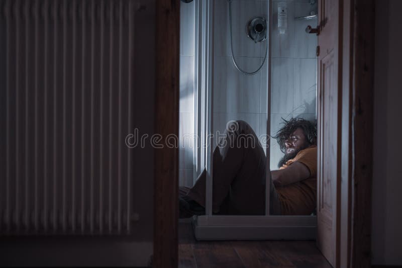 Distressed or Deranged Man Dressed Sitting in the Shower Traumatizing ...