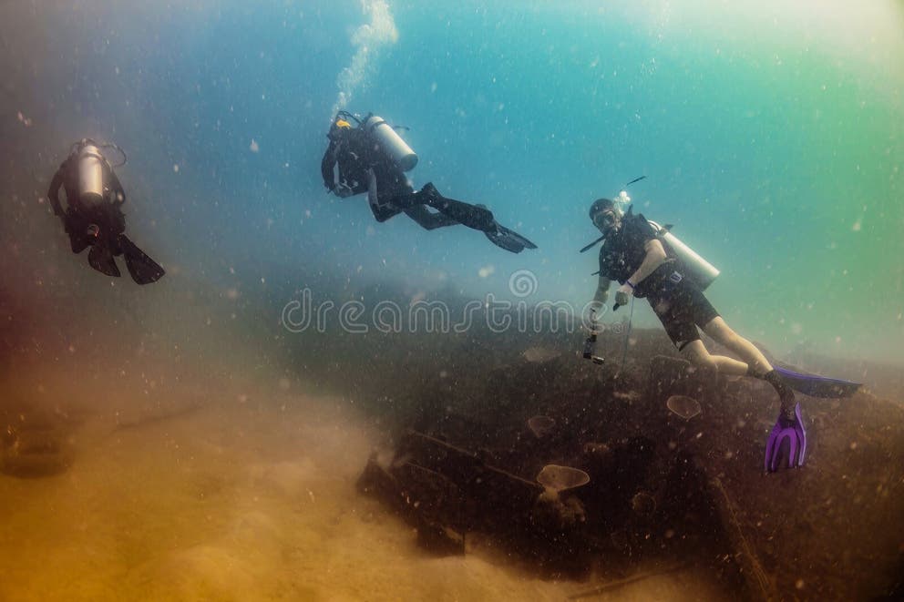 Divers Exploring Muddy Shipwreck in Deep Ocean Adventure Stock Image ...