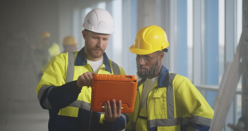Diverse Builders Inside House Being Renovated Using Digital Tablet ...