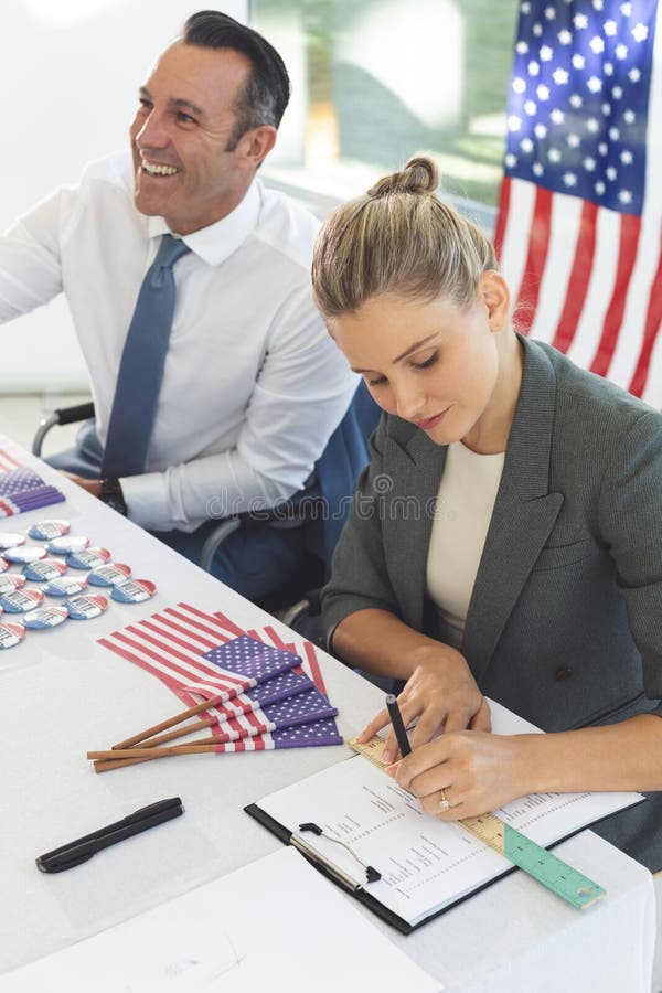 Diverse Business People Sat Next To Desk, Smiling and Writing Stock ...