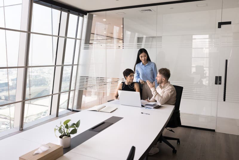 Diverse Business Project Workgroup Talking at Laptop in Meeting Room ...