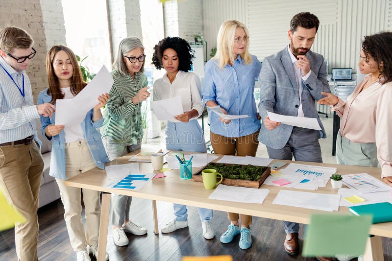 Diverse Business Team Analyzing Documents and Graphs Together in a ...