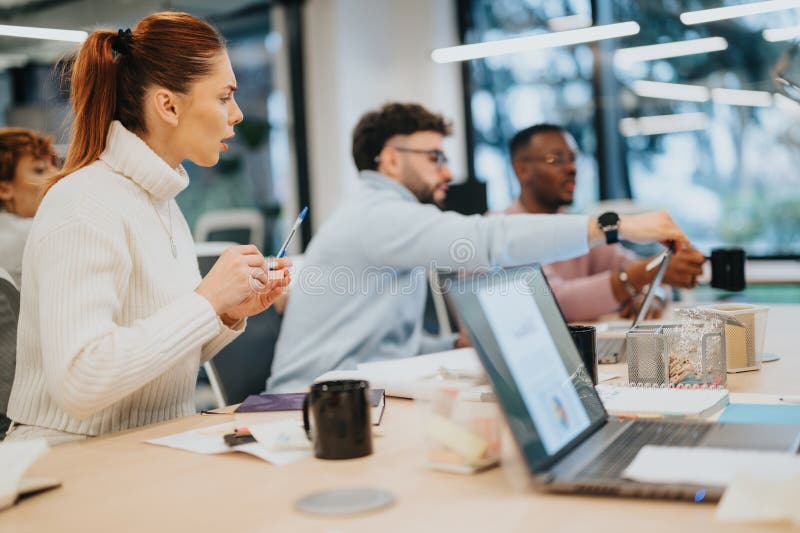 Diverse Business Team Collaborates in an Office, Reviewing Documents ...