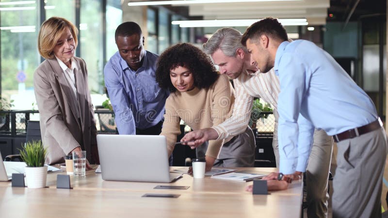 Business Team Collaborating on Project Using Laptop in Modern Office ...