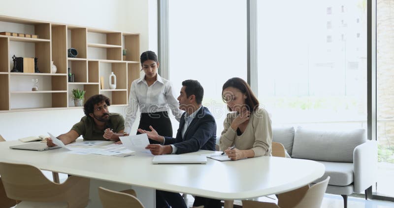 Diverse Business Team of Serious Colleagues Discussing Paper Reports ... Diverse Business Team of Serious Colleagues Discussing Paper Reports ...