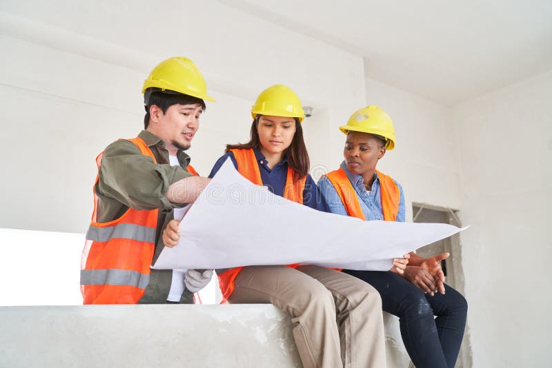 Diverse Construction Workers Discussing while Examining Blueprint of ...