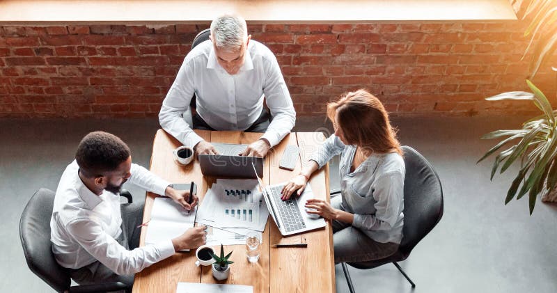Diverse Coworkers Working Using Computers Sitting at Desk in Office ...