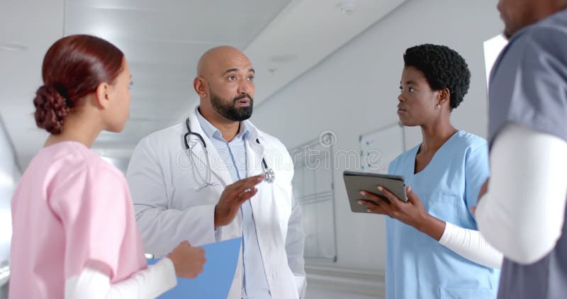 Diverse Doctors Discussing Work and Using Tablet in Corridor at Hospital, Slow Motion Stock ...