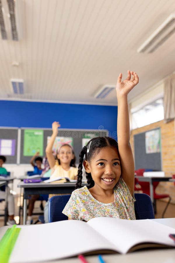 Diverse Elementary Schoolchildren Sitting at Desks and Raising Hands in ...