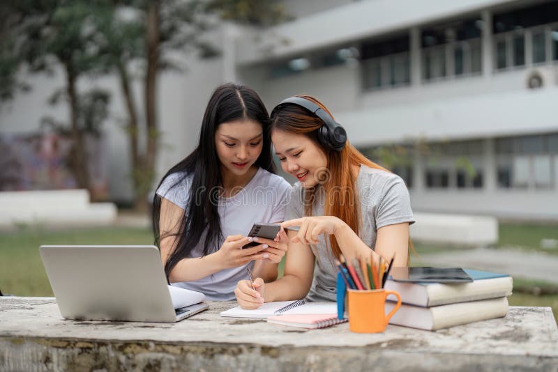 Diverse Female Students Sharing a Mobile Device and Studying Together ...