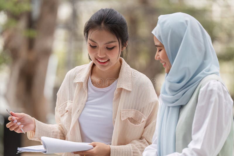 Diverse Female Students Sharing Notes and Smiling during Study Session ...