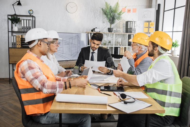 Diverse Group of Architects, Engineers Sitting at Table with Modern ...