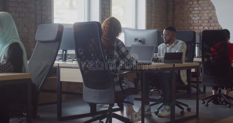 A Diverse Group of Business Colleagues Engage in Discussions about ...