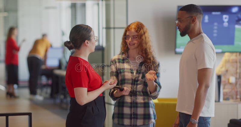 A Diverse Group of Business Colleagues Engage in Discussions about ...