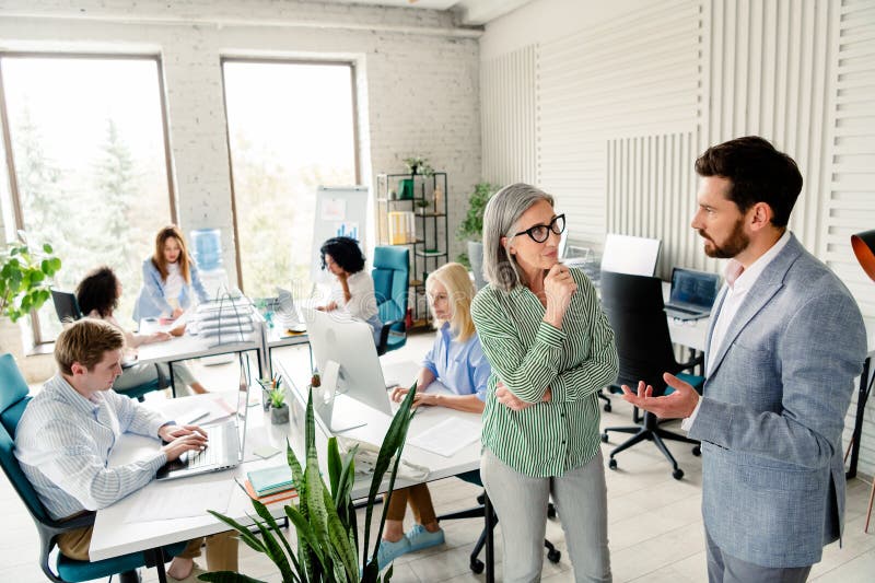 Group of Professionals Engaged in Teamwork and Discussions in a Modern ...