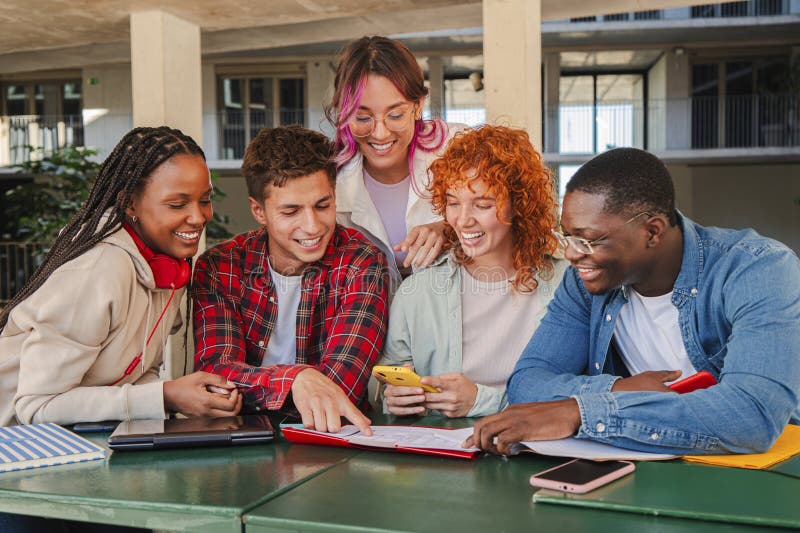 Diverse Group of College Teenage Students Studying Together, Looking at ...