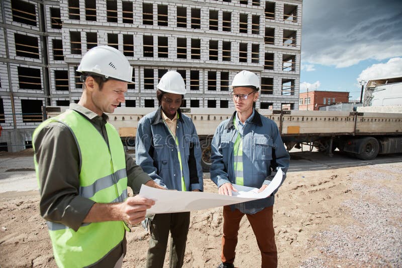 Three Construction Workers Holding Blueprint Stock Image - Image of ...