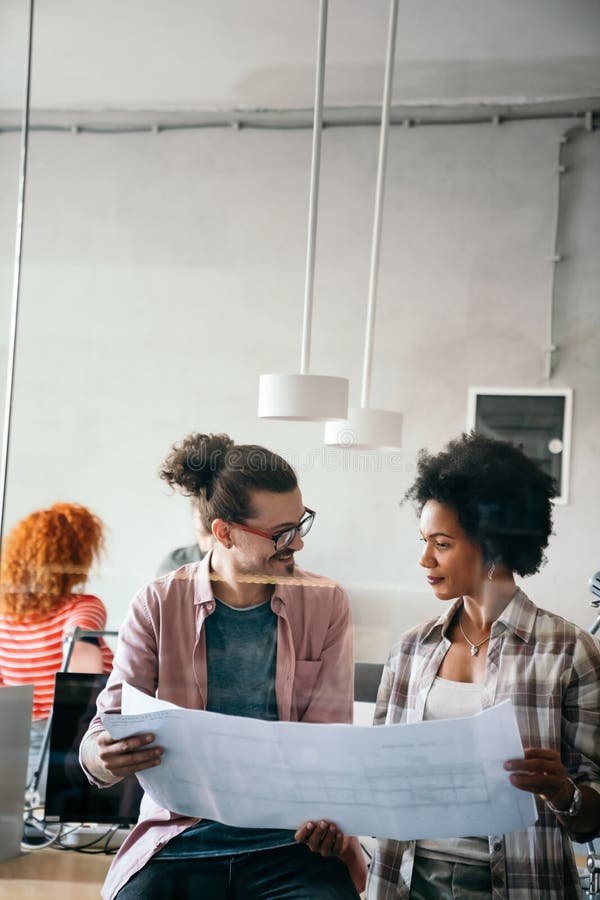 Diverse Group of Happy Employees Analyzing Reports Together with Papers ...