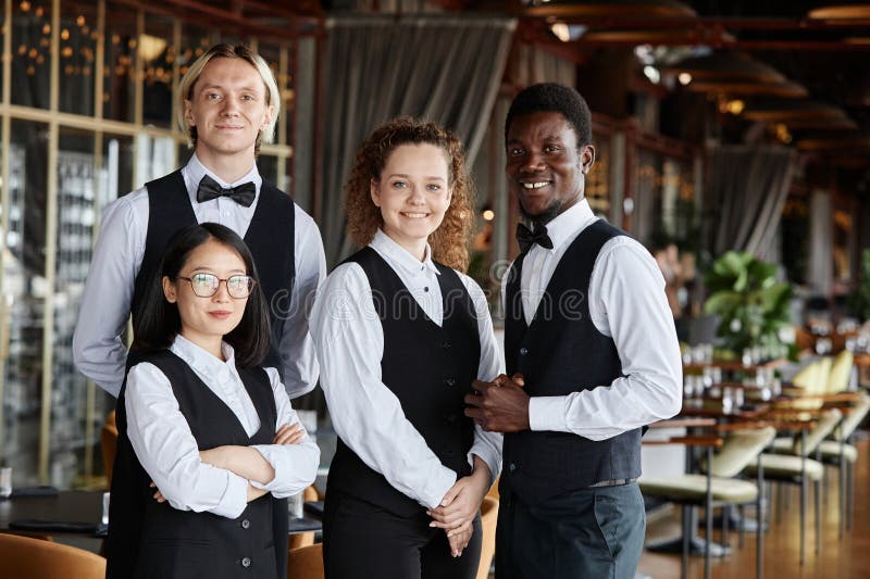 Diverse Group of Servers Wearing Classic Tuxedo Uniform Smiling at ...
