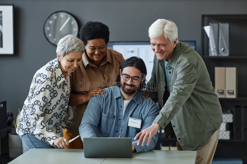 Diverse Group of Smiling Senior People Using Laptop with Man in ...