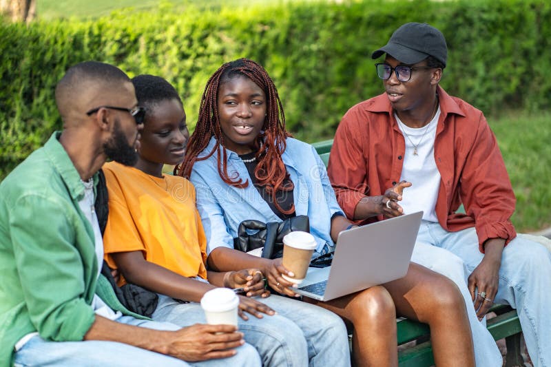 Interracial Friends Group Enjoying Coffee in Park with Laptops ...