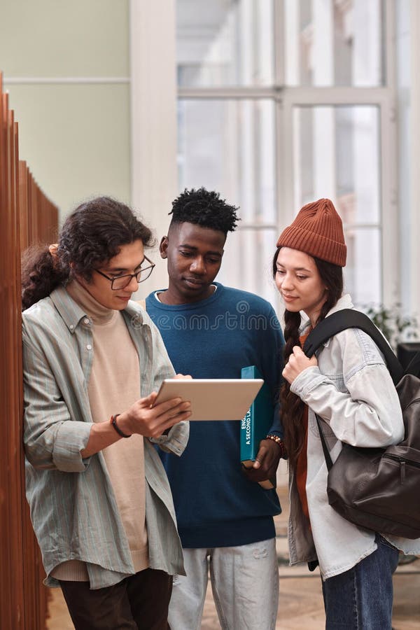Diverse Group of Three Young Students Looking at Tablet Screen Stock ...