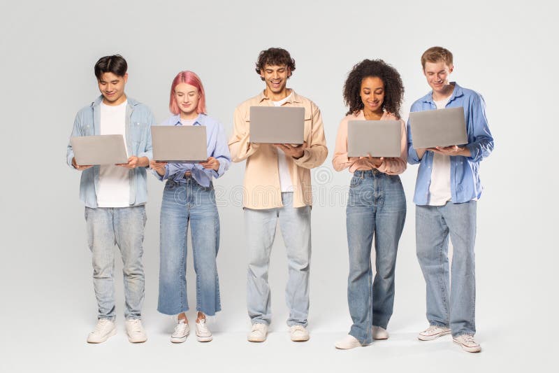 Diverse Group of Young Adults Using Laptops in Studio Setting Stock ...