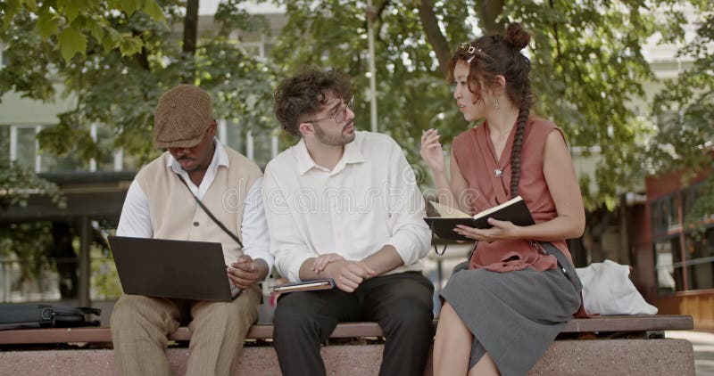 A Diverse Group of Young Professionals Collaborating Outdoors, Working ...