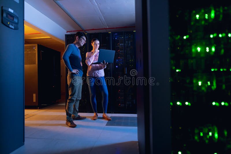 Diverse Male and Female Engineers Using Laptop in Computer Server Room ...