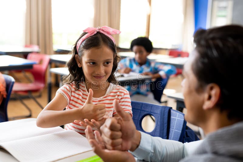 Diverse Male Teacher Teaching School Girl Using Sign Language in Class ...