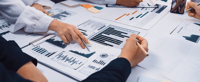 Diverse Professionals Collaborating on Business Reports and Data Analysis in Modern Office ...