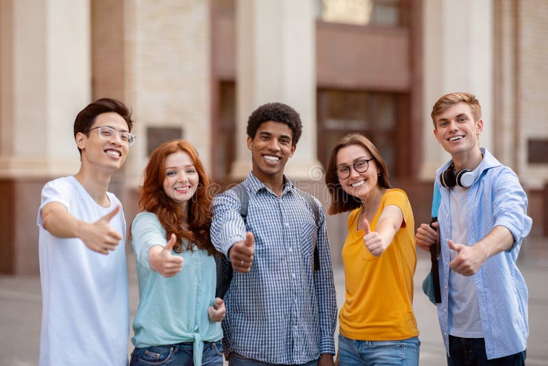 Diverse Students Gesturing Thumbs-Up Smiling To Camera Standing Outside ...