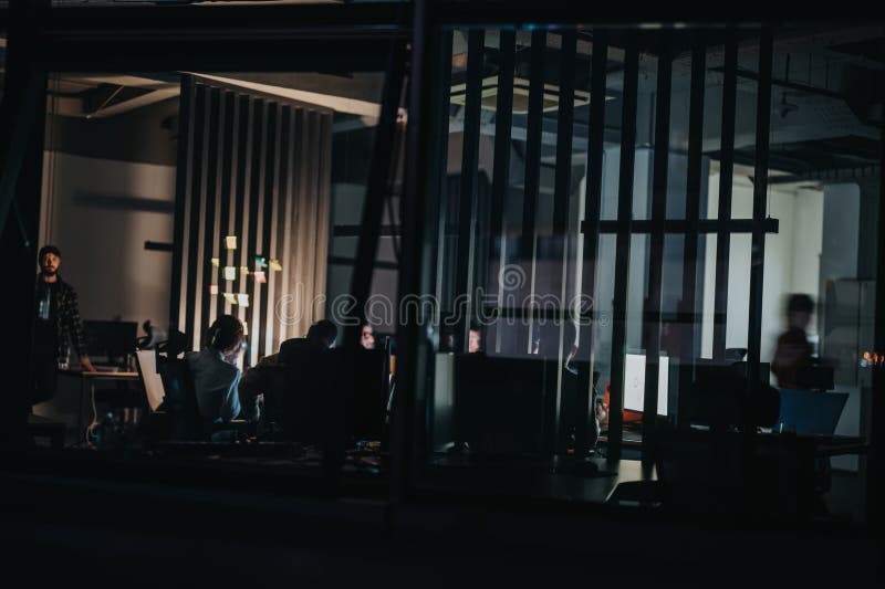 Diverse Team Collaborating Late at Night in a Modern Office Setting ...