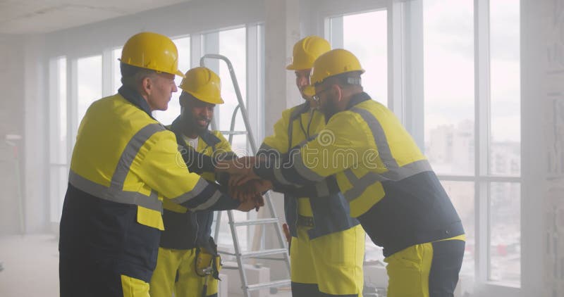 Diverse Group of Construction Workers Collaborate on a Construction ...