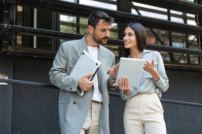 Diverse Team of Corporate Professionals in Formal Attire Collaborating Outdoors, Engaged in ...