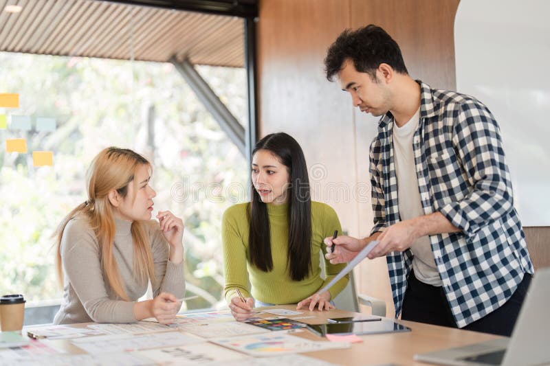 Diverse Team Deep in Discussion while Analyzing Design Materials in an Office. Stock Photo ...