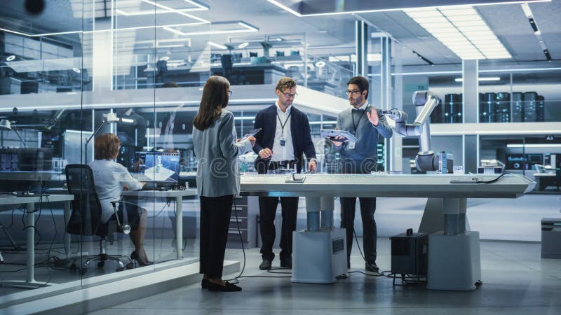 Diverse Team of Industrial Robotics Engineers Gathered Around a Table ...