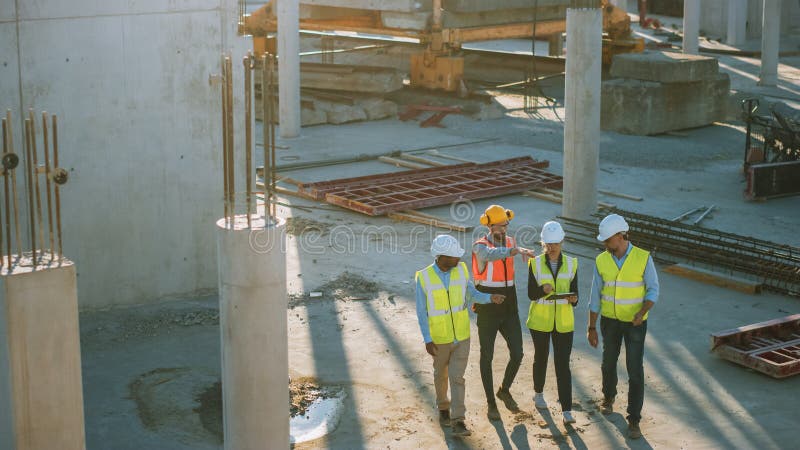 Diverse Team of Specialists Discussing Work on Construction Site. Real ...