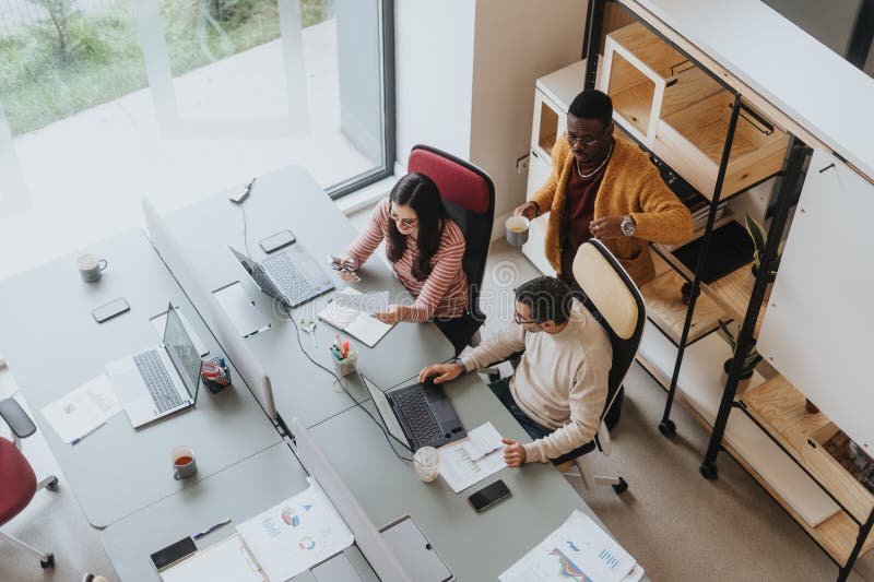 Diverse Team Working in Modern Office with Laptops and Documents. Stock ...