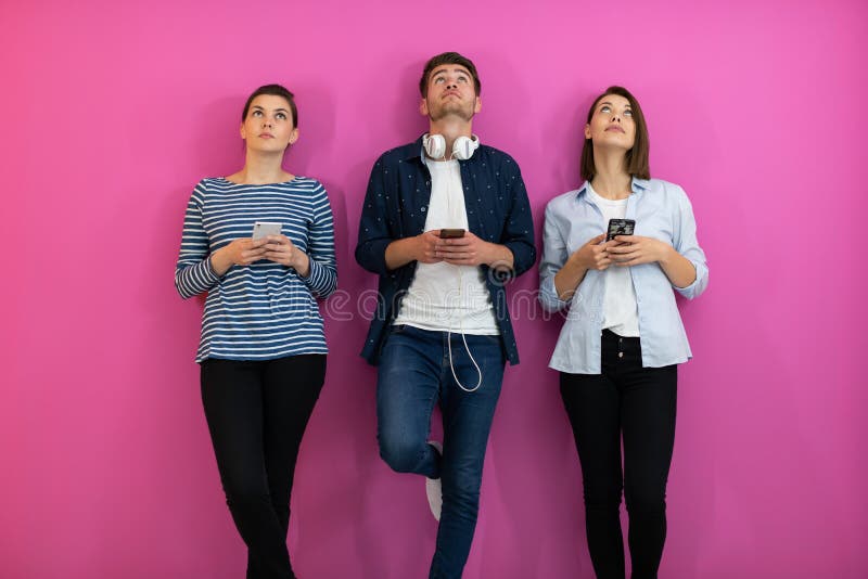 Diverse Teenagers Using Mobile Devices while Posing for a Studio Photo ...