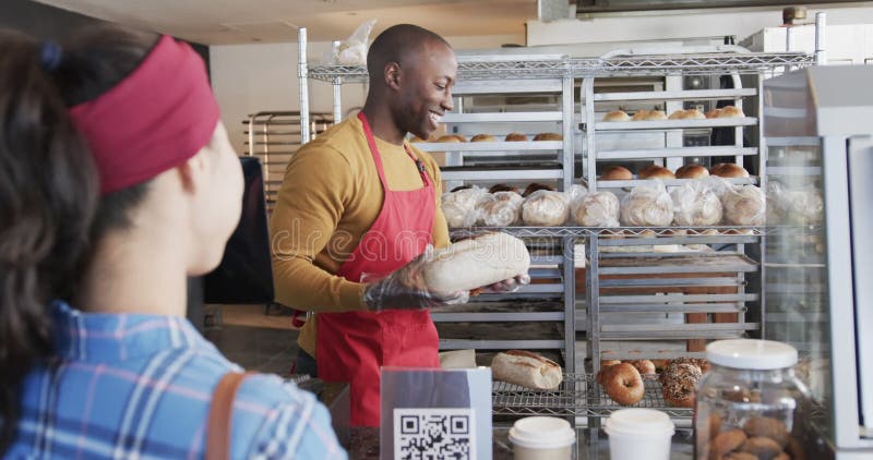 Diverse Worker and Customer Offering Fresh Bread in Bakery in Slow ...
